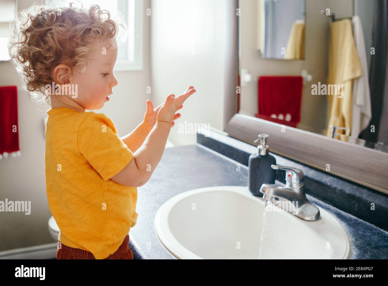 Little Caucasian boy toddler washing hands in bathroom at home. Health ...