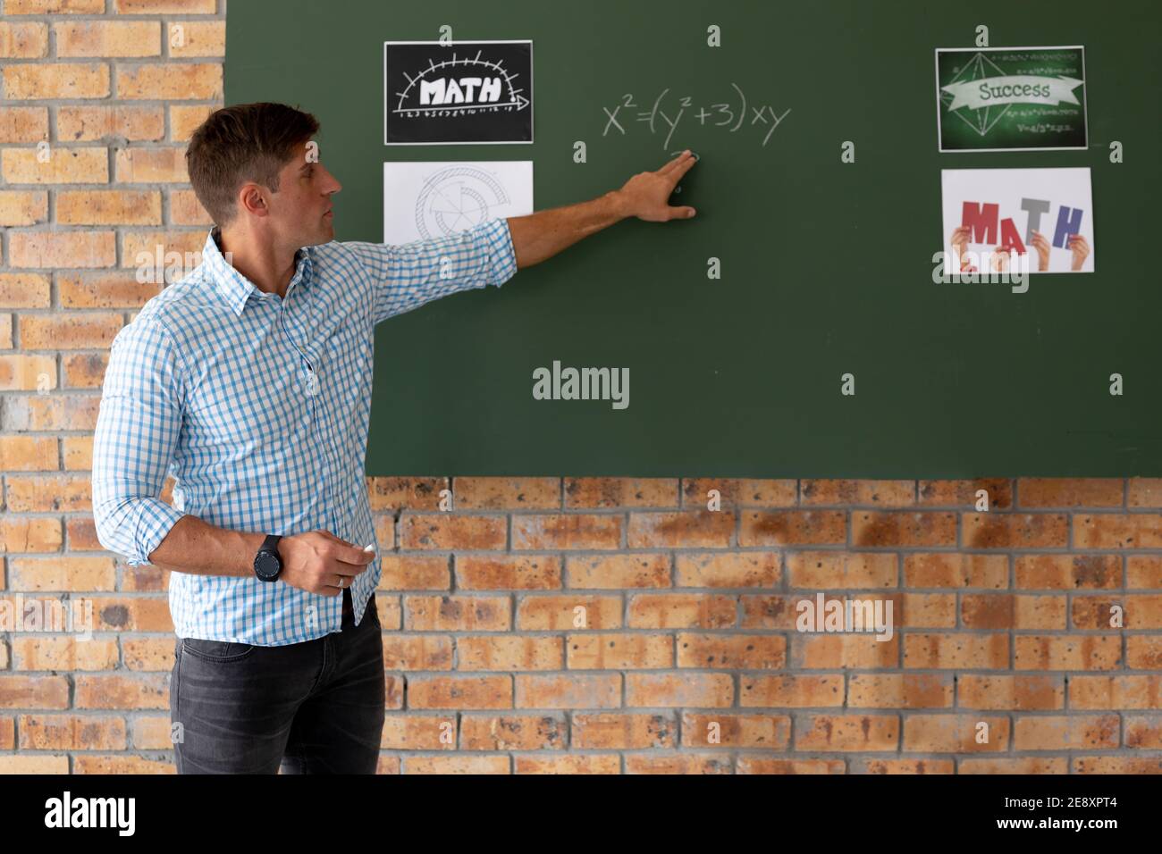 Male caucasian teacher teaching mathematics in the classroom at school ...