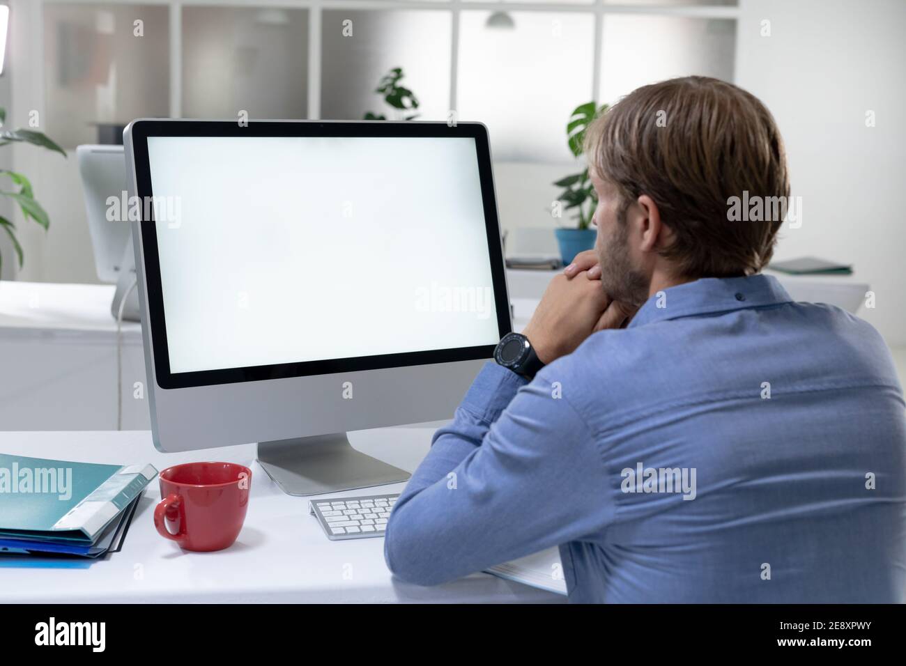 Rear view of caucasian businessman sitting at desk making video call ...