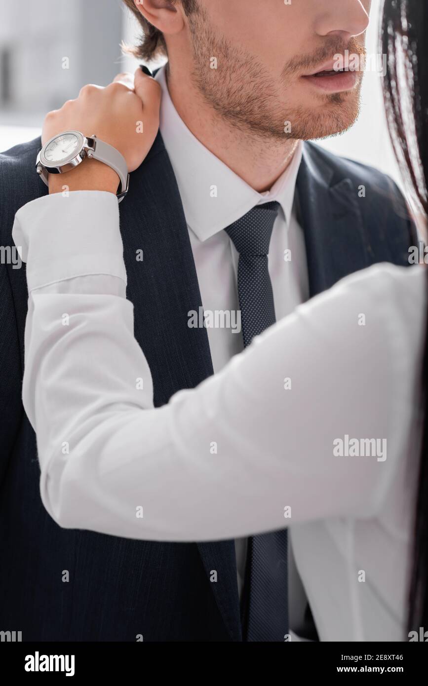 cropped view of businessman flirting with colleague and touching his ...