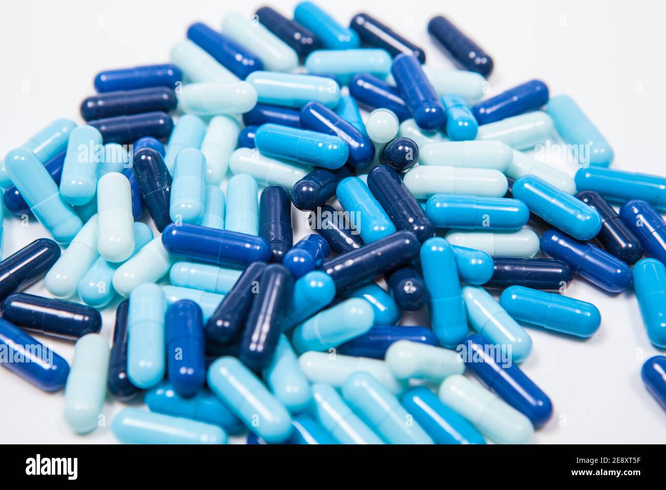 Pile of blue capsules isolated on white Stock Photo - Alamy