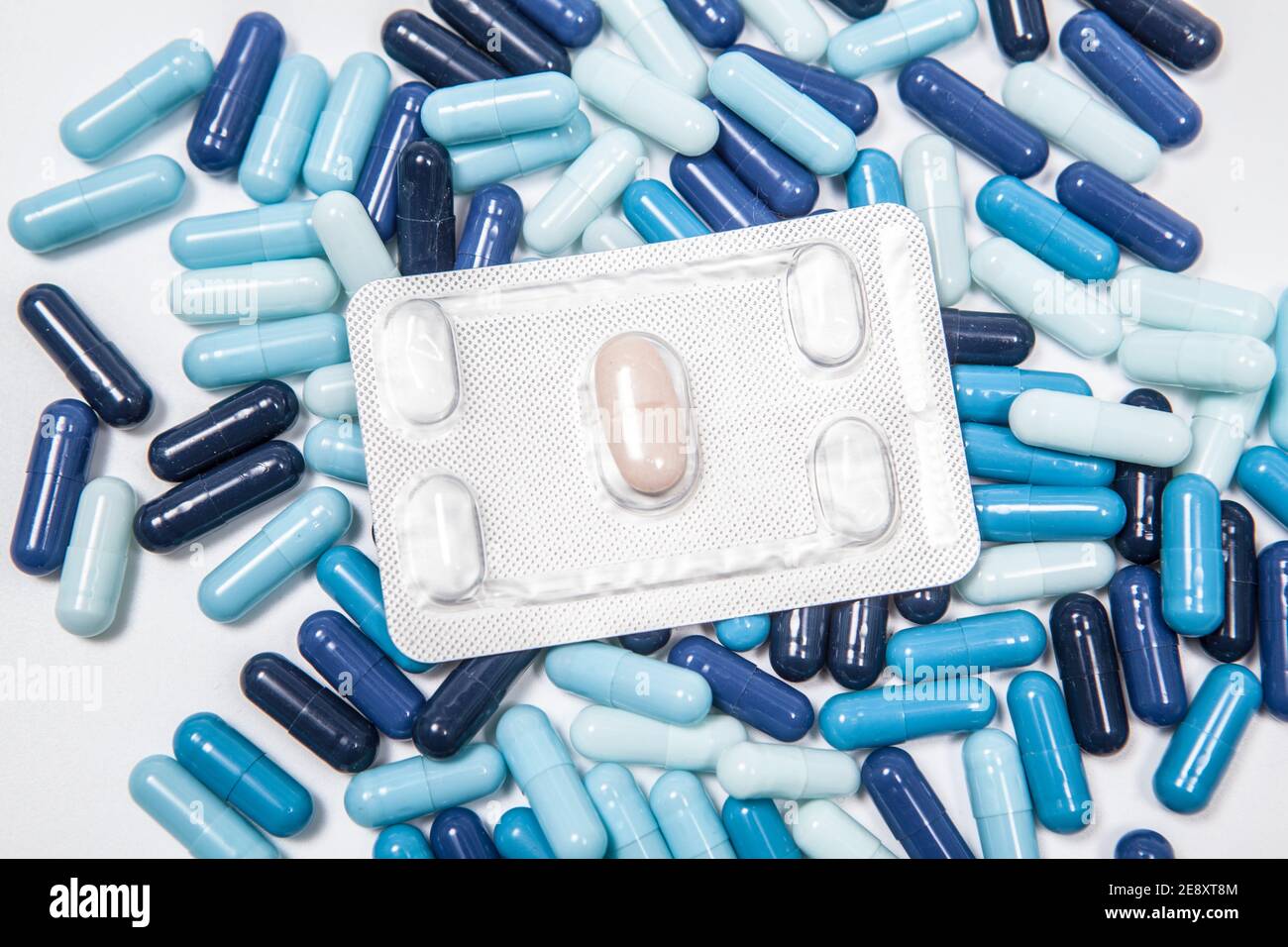 Antibiotic pill on a blister on a pile of colorful medicament capsules ...