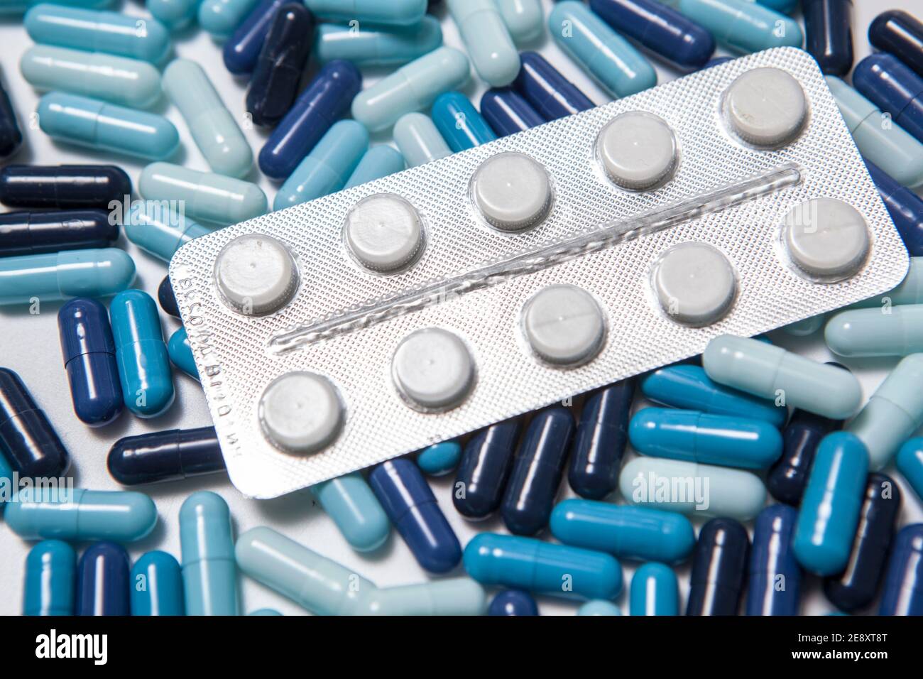 Pills in blister on pile of colorful medicament capsules Stock Photo ...