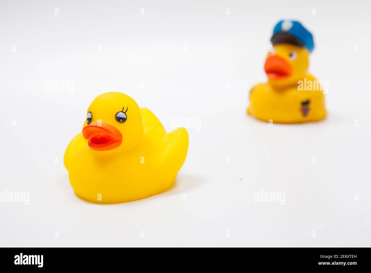 Criminal rubber duck getting away from rubber duck cop Stock Photo - Alamy