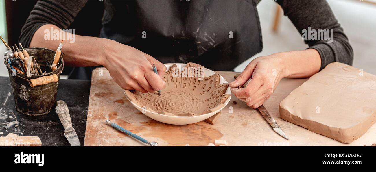 Woman using pottery tools for making patterns Stock Photo - Alamy