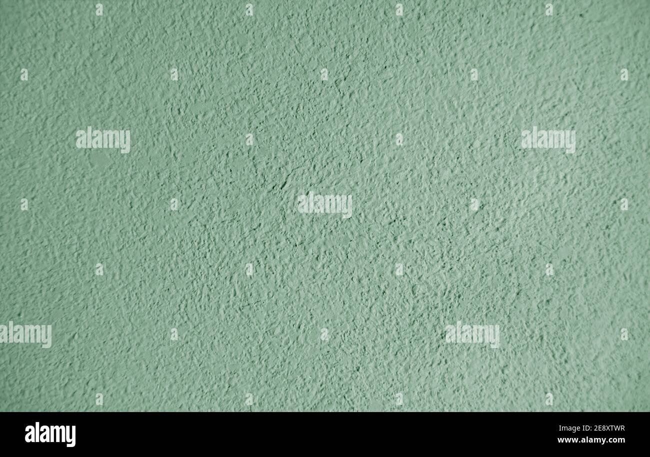 Abstract grainy texture on light green wall. It can be used as a design ...