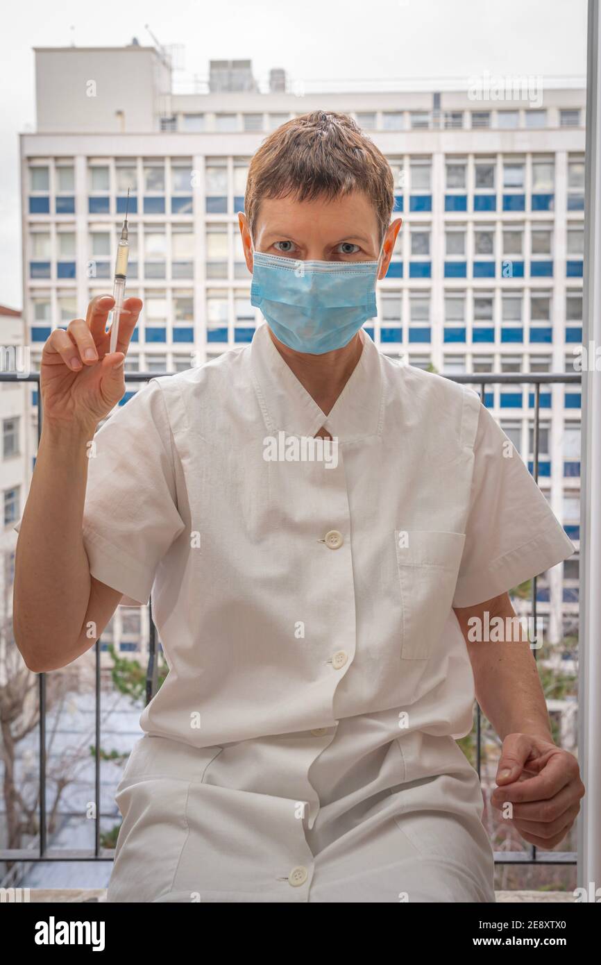 Paris, France - 31 01 2021: Masked nurse dressed in a white lab coat ...