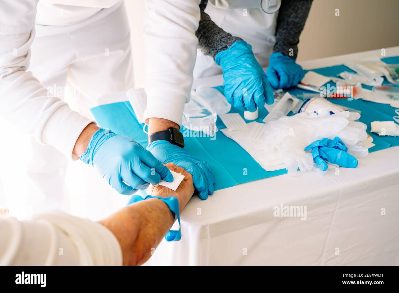 Nurses caring for an elderly patient by administering an intravenous ...