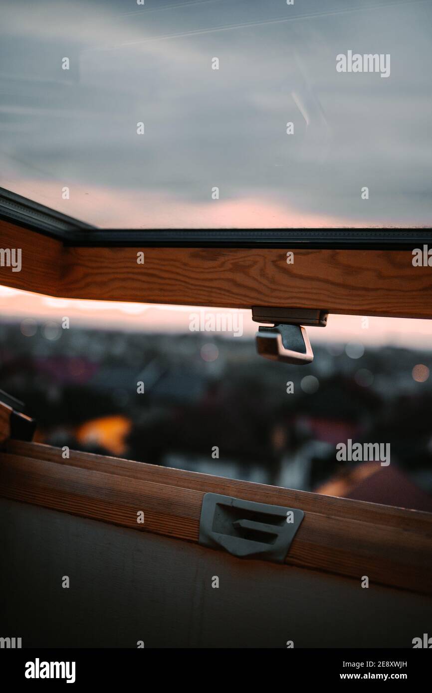 Vertical shot of the colorful sunset over a city captured from a window ...