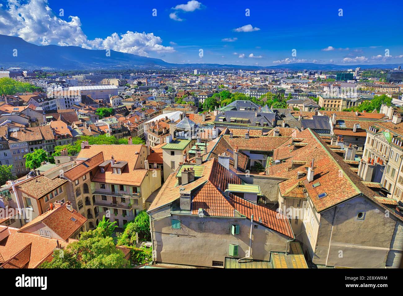 Aerial view of Geneva old city with its roofs, buildings and Swiss alps ...