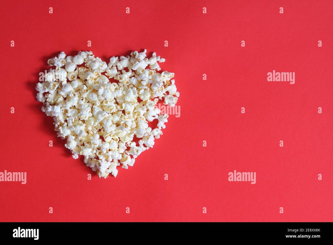 Love cinema concept of popcorn. Heart shaped white fluffy popcorn on ...