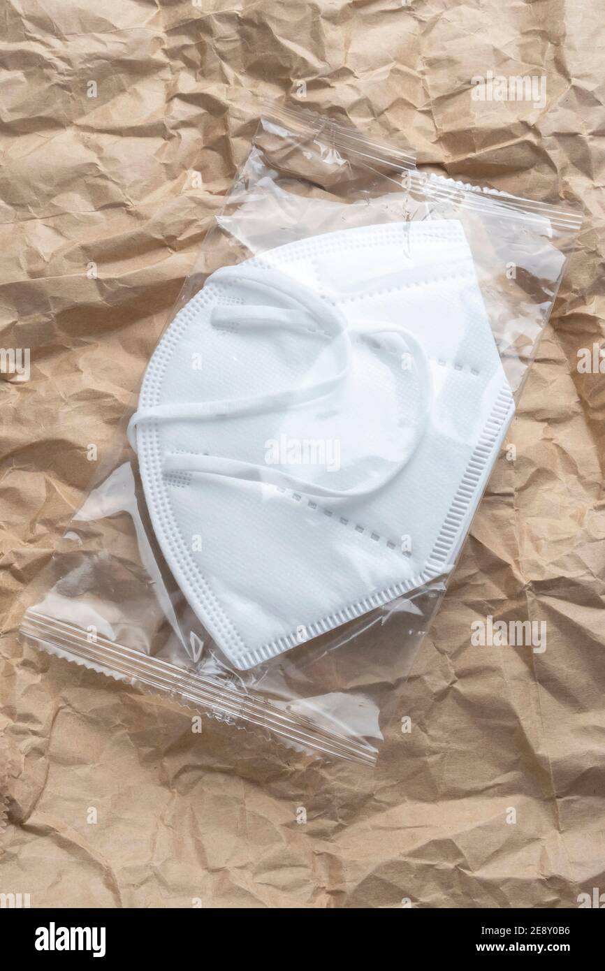 White medical respiratory mask kn95. Plastic package. Blue wooden ...