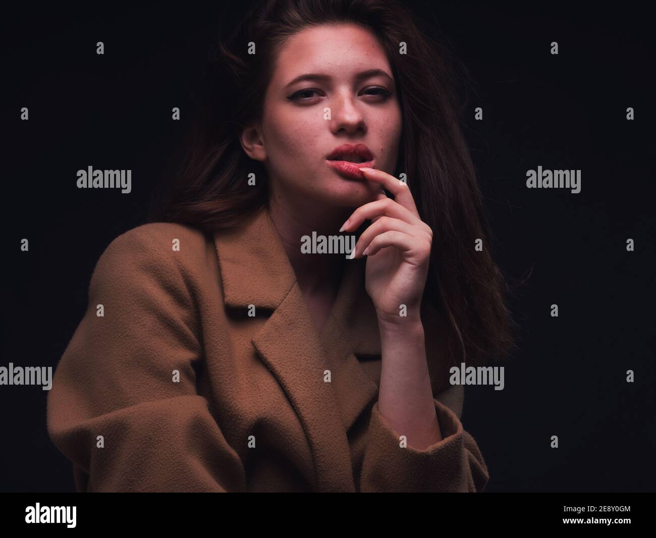 one young woman posing, looking at camera, touching her lip sensualy with her fingers Stock ...