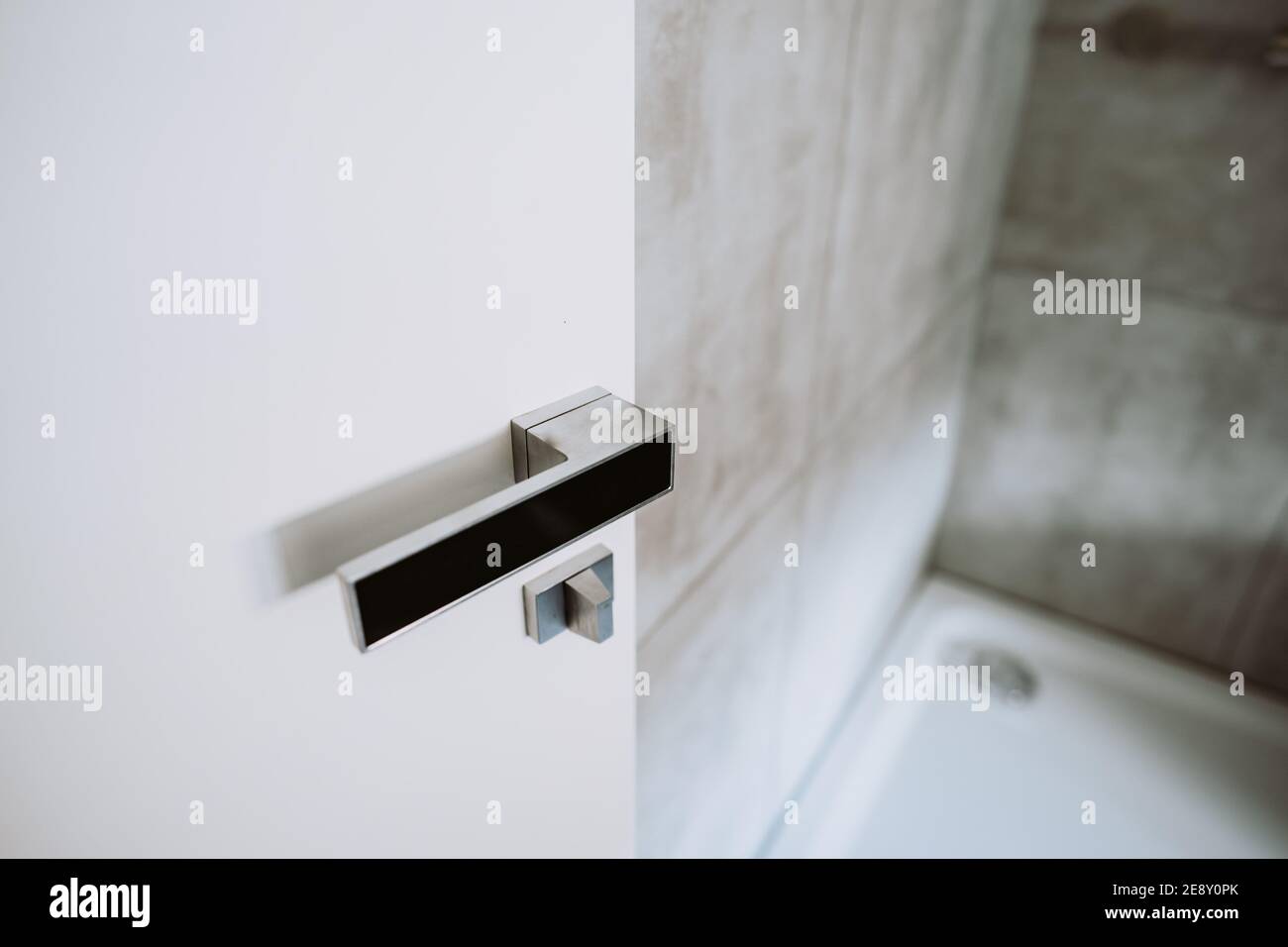 a modern silver door handle of a shower Stock Photo - Alamy