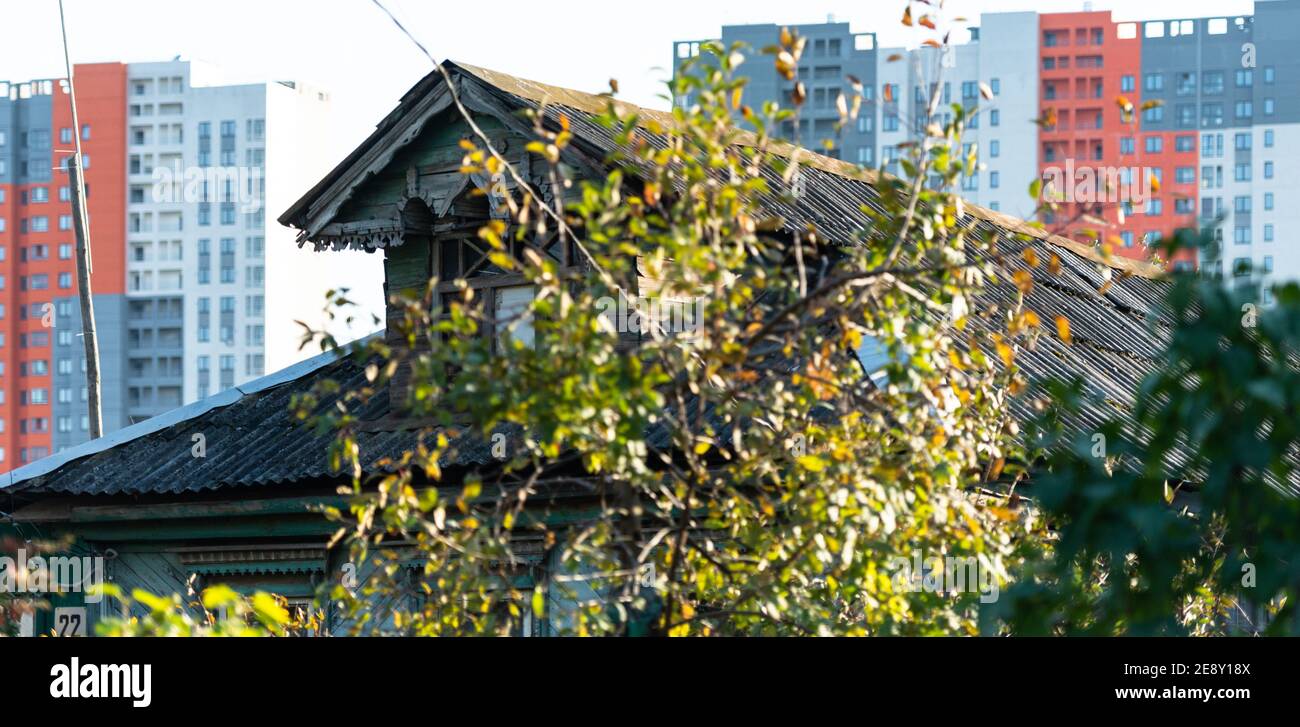 Old wooden house on the background of multi-storey buildings Stock ...