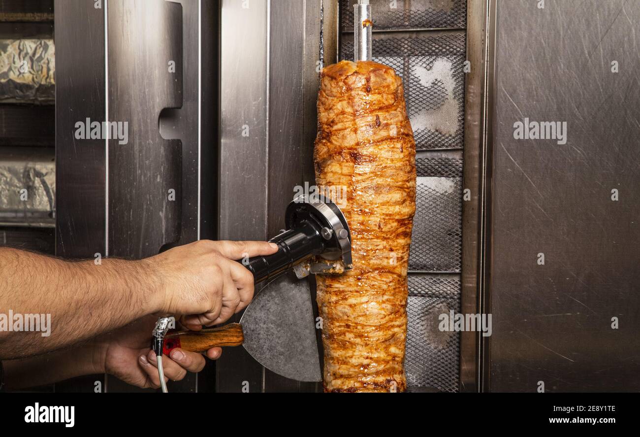 Closeup shot of a male cutting kebab meat with an electric knife Stock ...