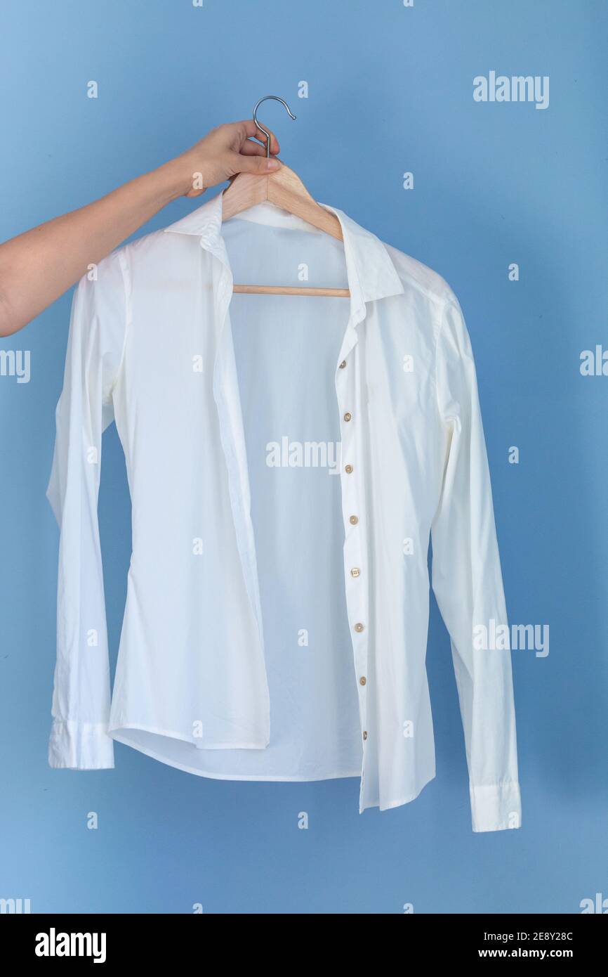 hand holding a white empty cloth on a shoulder, blue background Stock ...