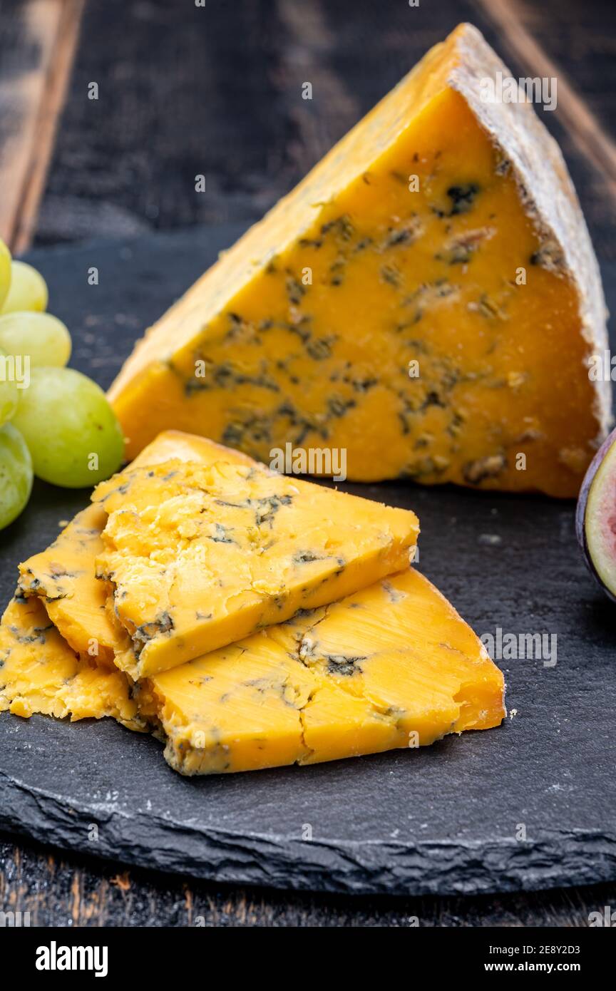 British matured yellow cheese blue shropshire, close up on black stone ...