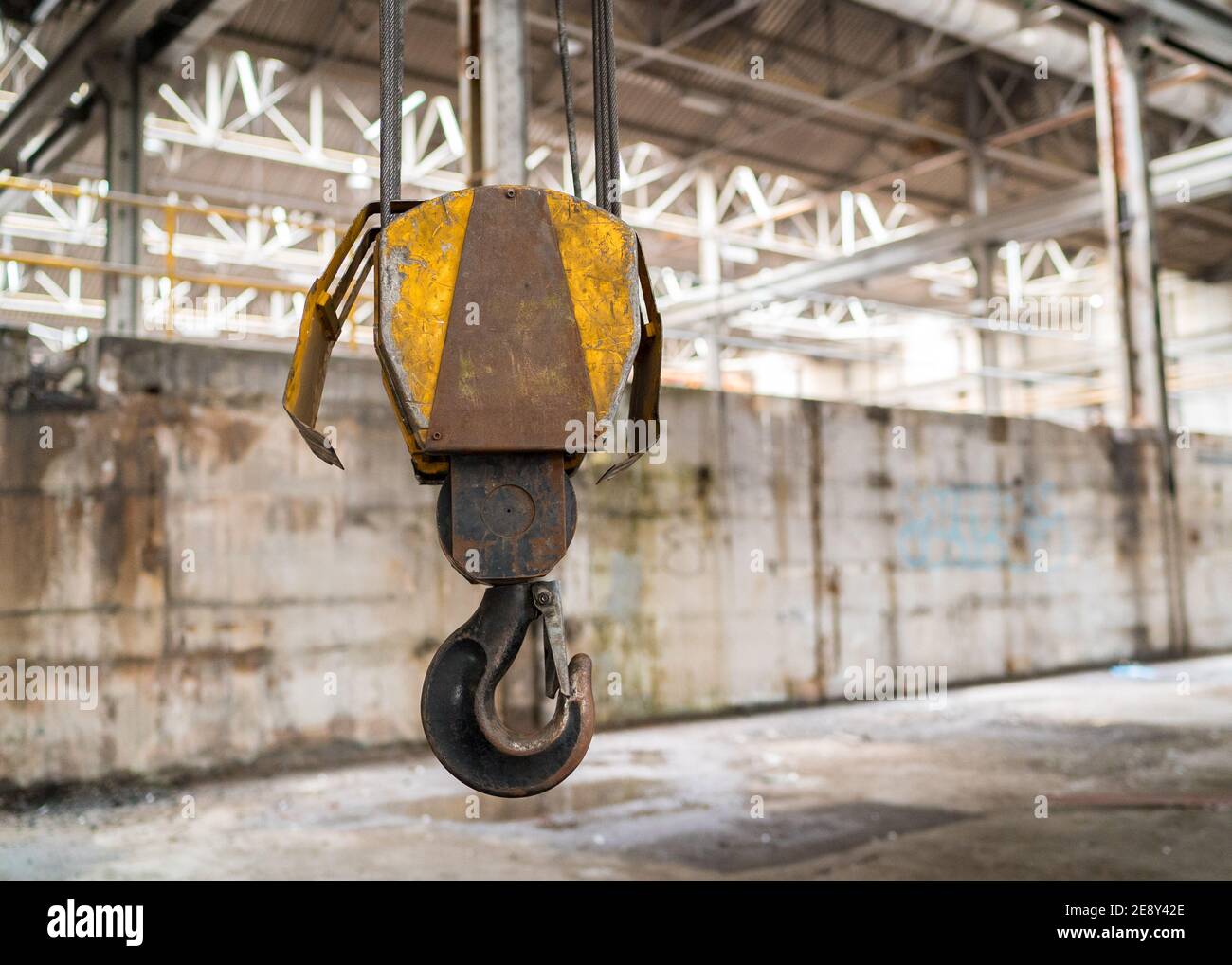 Yellow heavy duty isolated lifting pulley crane hook in industrial ...