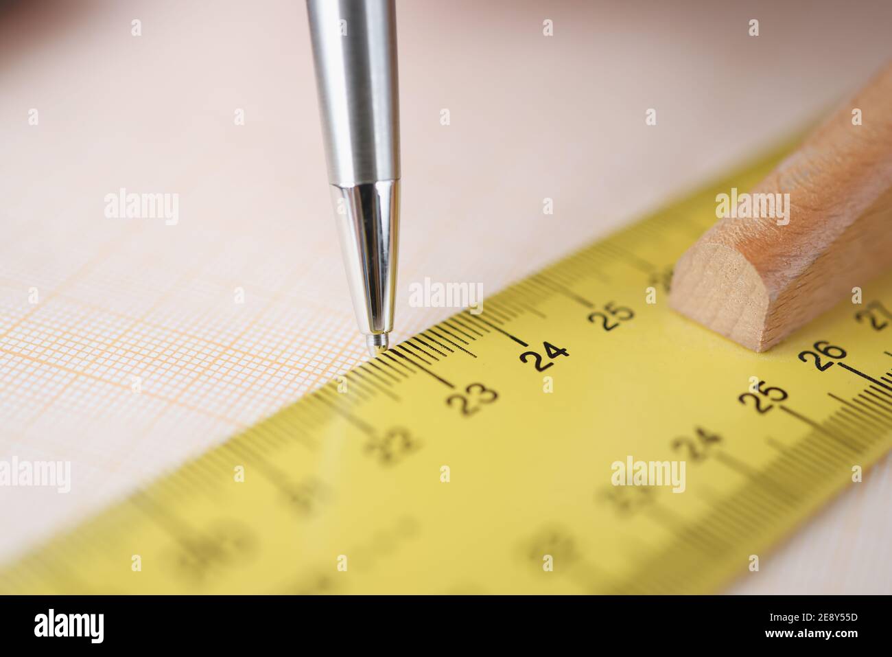 Ballpoint pen drawing line under ruler on graph paper closeup Stock ...