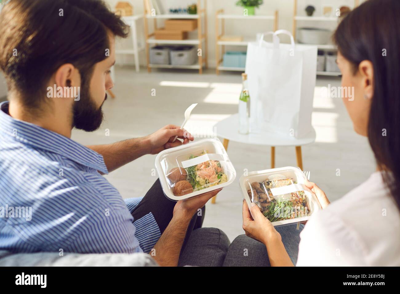 Man and woman holding containers of healthy takeaway food delivered by ...