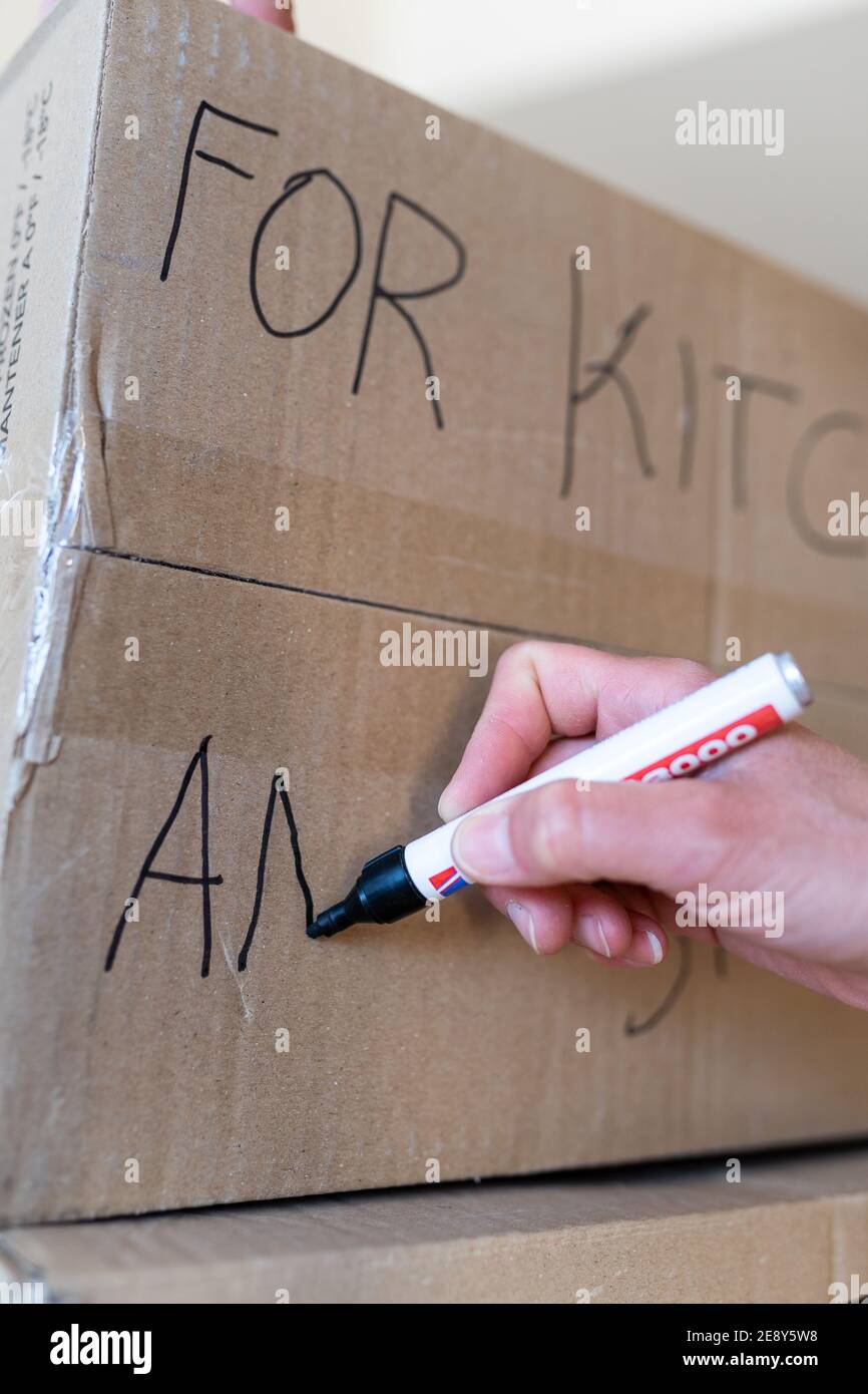 Mom writing boxes to move into a new house Stock Photo - Alamy