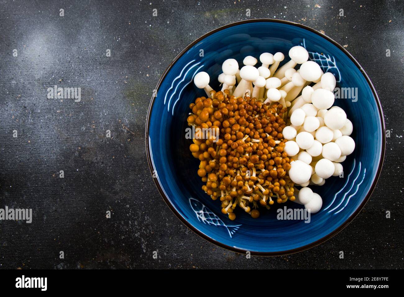Golden brown and white Asian Enoki mushrooms, vegetable background ...