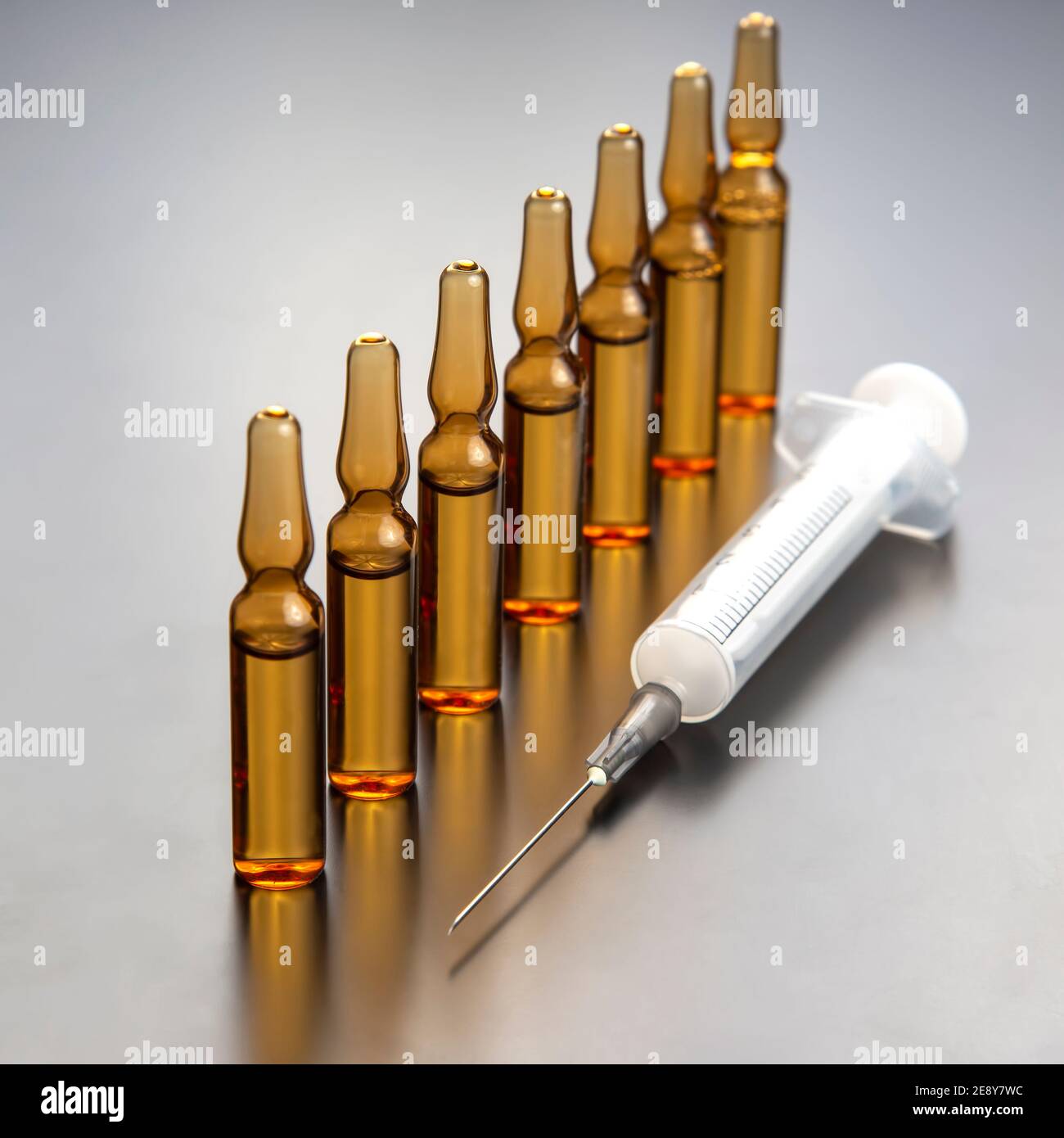 seven medical glass ampoules for injection drug on a gray background ...