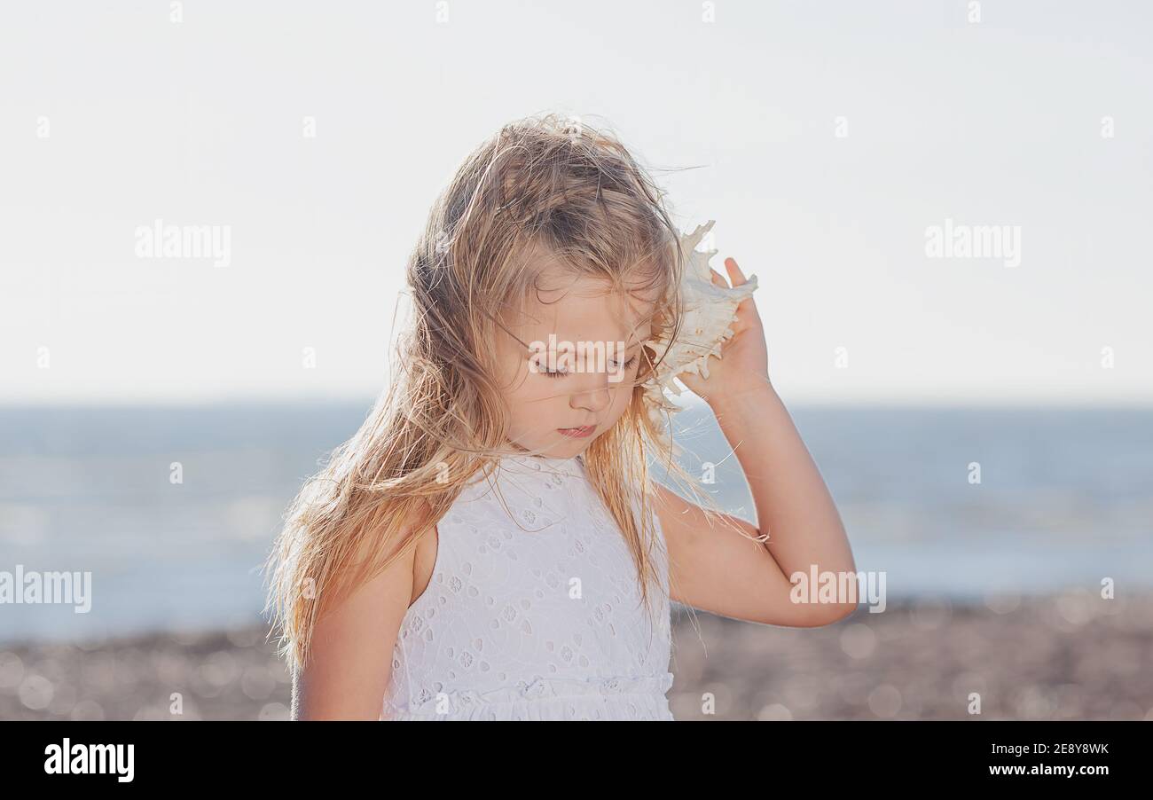 Little girl with seashell hi-res stock photography and images - Alamy