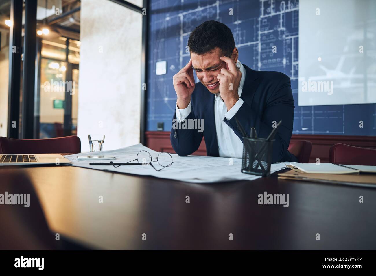Engineer having a splitting headache at work Stock Photo - Alamy