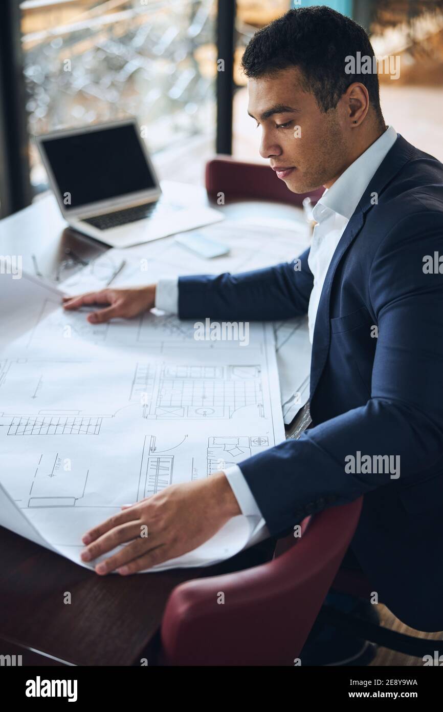 Concentrated draftsman staring at the building plan Stock Photo - Alamy