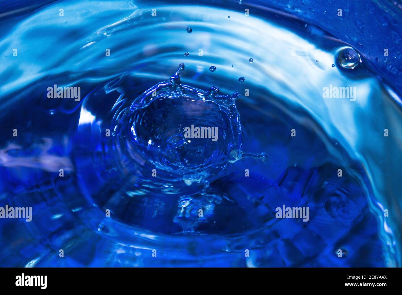 Closeup shot of clear blue water droplet with water surface in nature ...