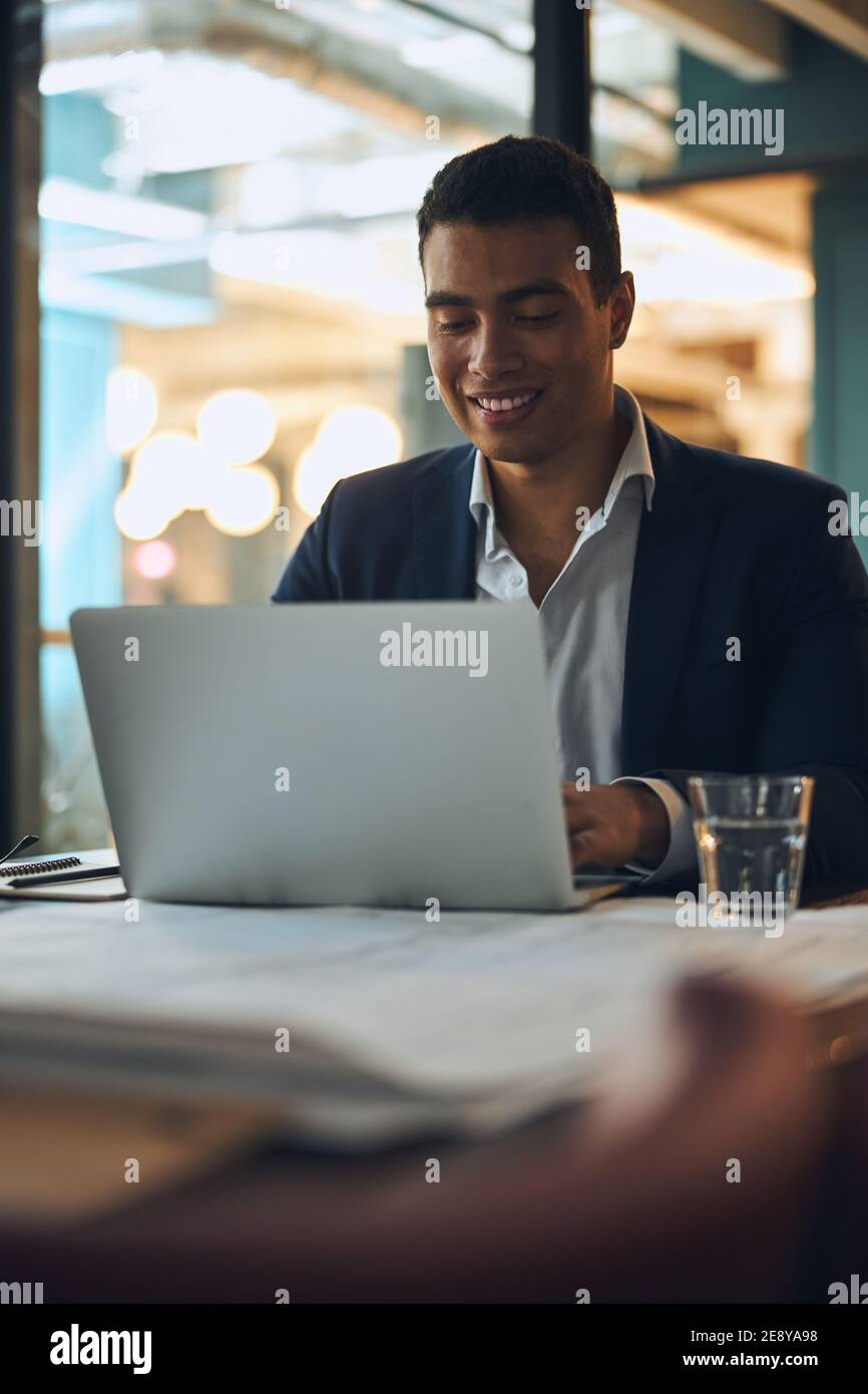 Pleased dark-haired employee typing on his computer Stock Photo - Alamy