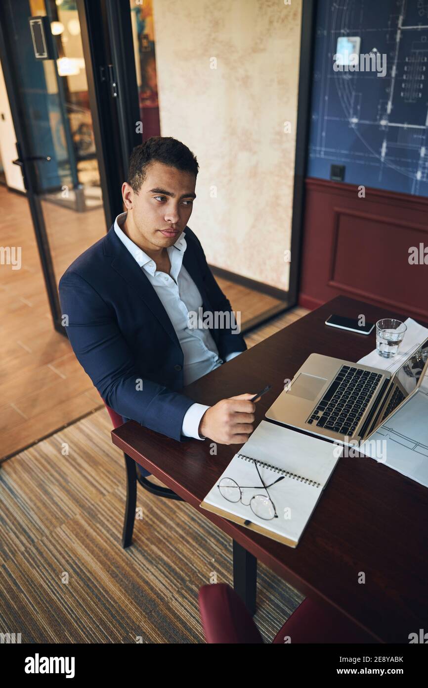 Pensive male employee seated at his desk Stock Photo - Alamy
