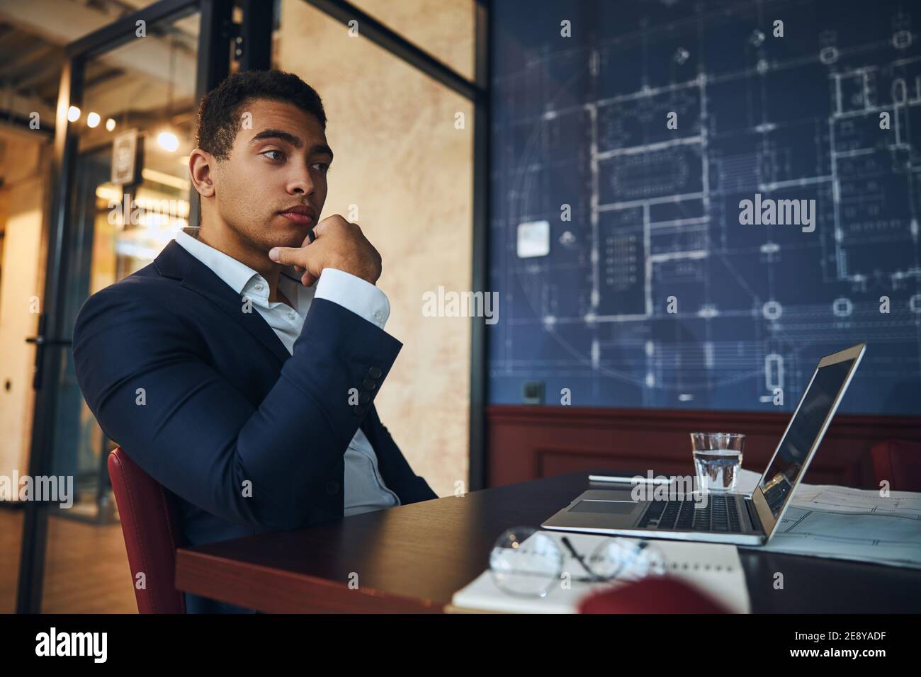 Pensive young engineer sitting at his computer Stock Photo - Alamy
