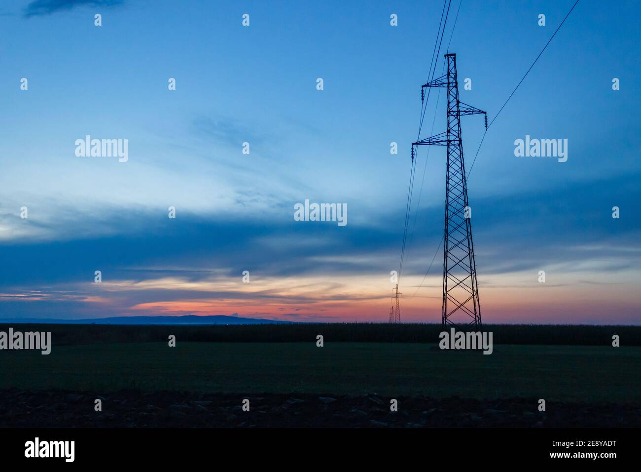 Beautiful twilight view behind transmission towers in a field Stock ...