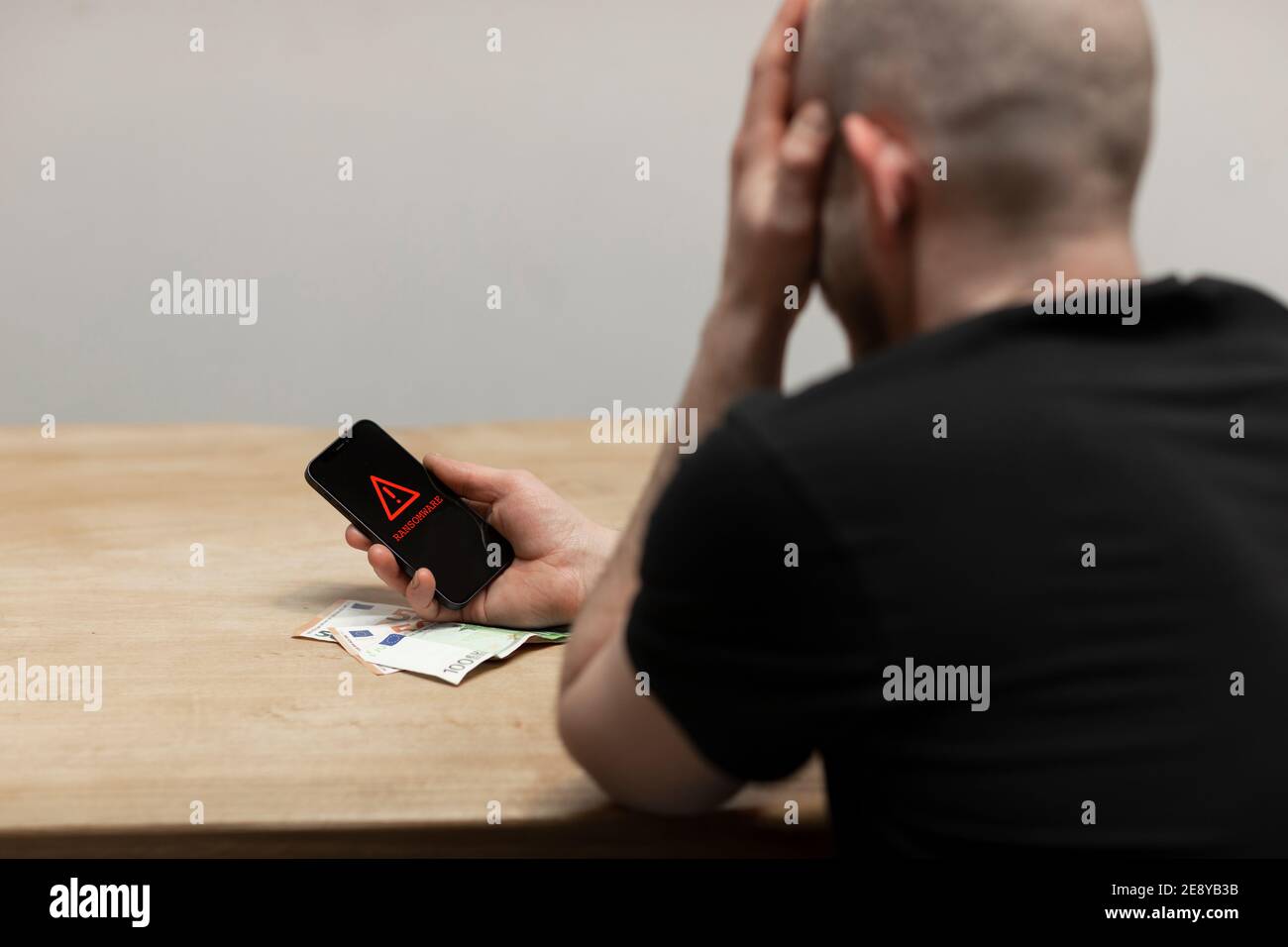A ransomware text and warning sign popping up on a cell phone screen. A ...