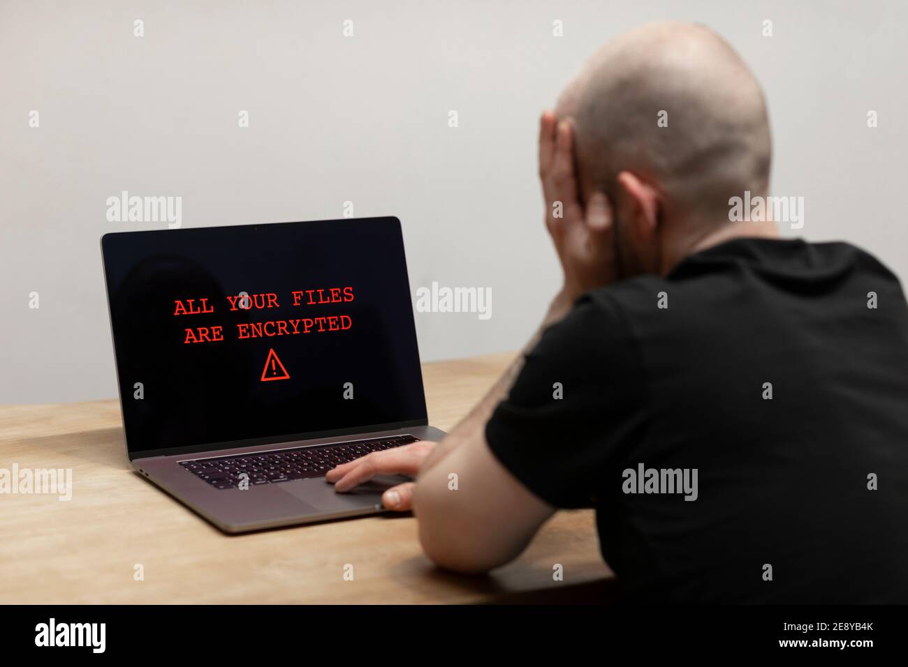 Red text saying ‘All your files are encrypted’ and a warning sign on a ...