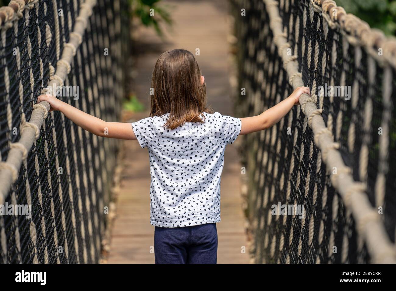 Little girl walking on a suspension bridge Stock Photo - Alamy