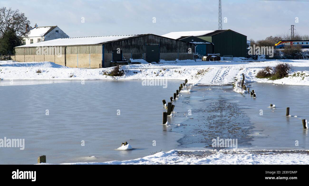 Frozen over farm road example Stock Photo - Alamy