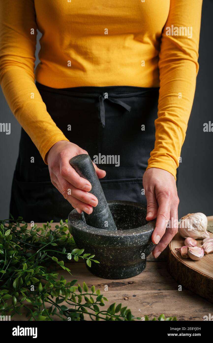 Female grinding pine nuts with mortar and pestle Stock Photo - Alamy