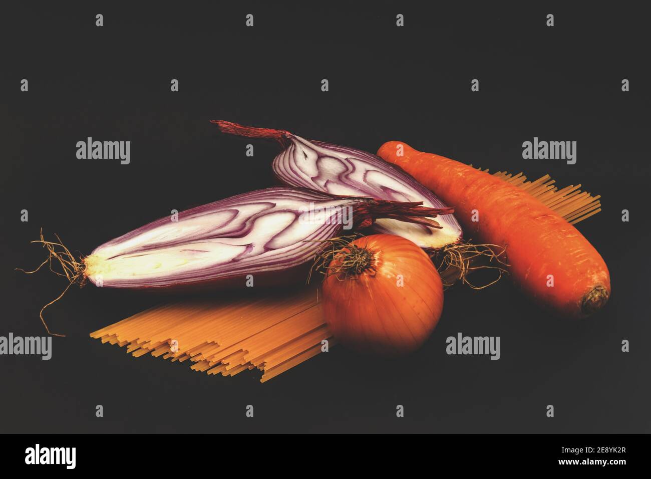 Spaghetti with long red florence onion and raw carrot on black ...