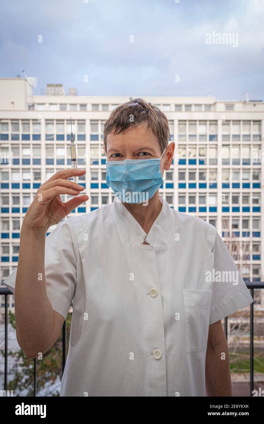 Paris, France - 31 01 2021: Masked nurse dressed in a white lab coat ...