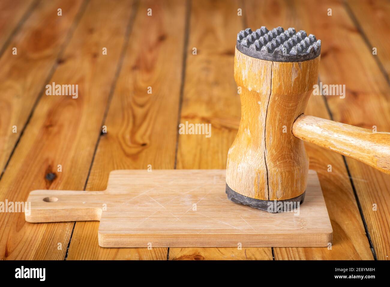 Wooden meat grinder on a chopping board. Wooden kitchen utensils on the ...