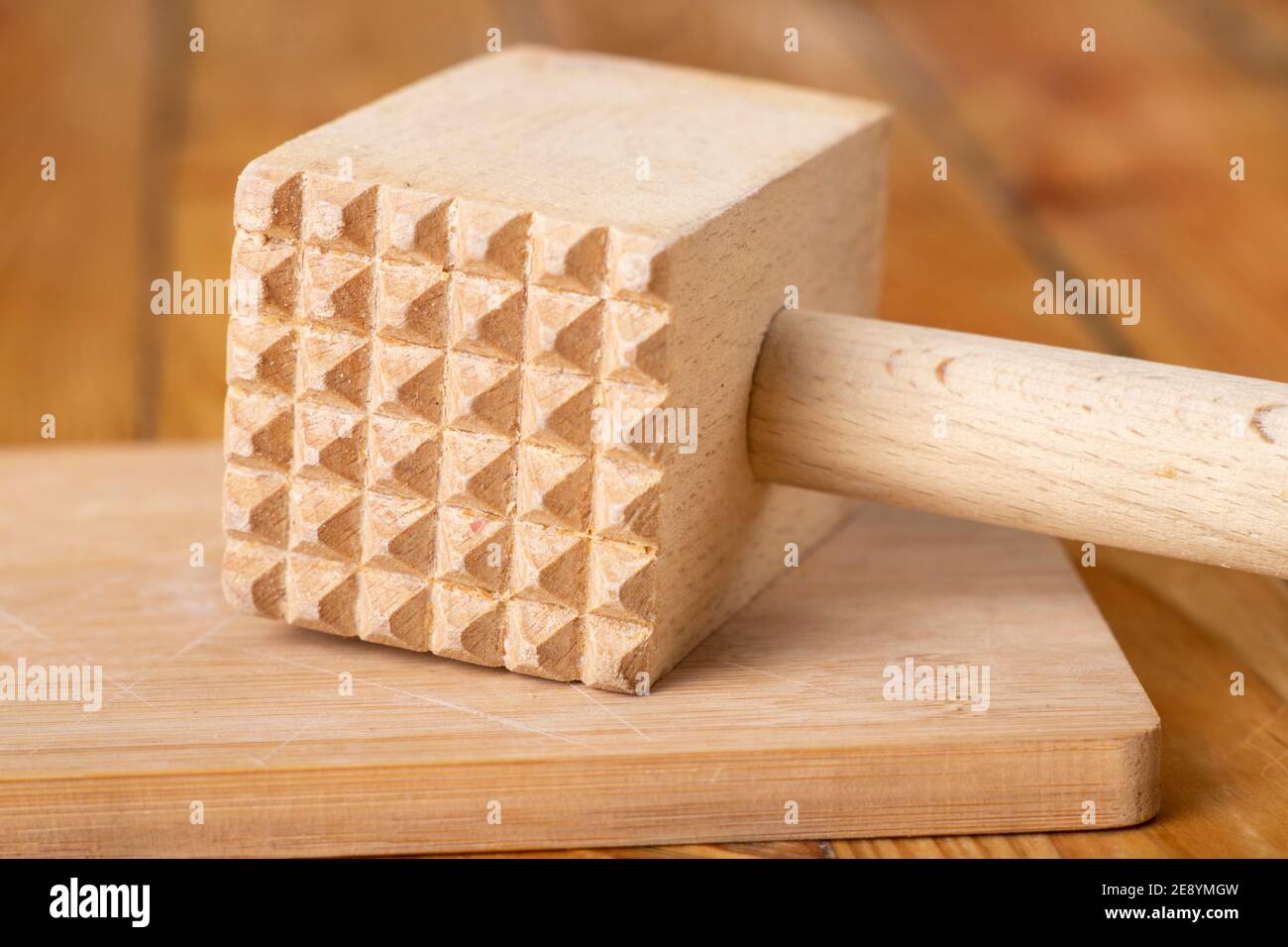 Wooden meat grinder on a chopping board. Wooden kitchen utensils on the ...