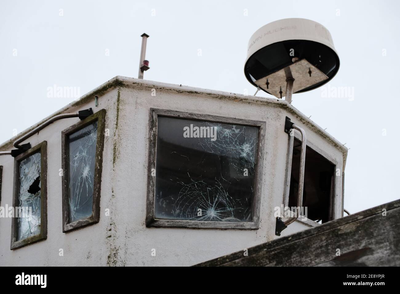 Boats on the shore at Dungeness in Kent, England. A boat with smashed ...