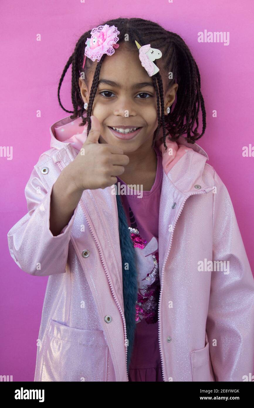 Portrait of a little mixed girl showing thumb up Stock Photo - Alamy