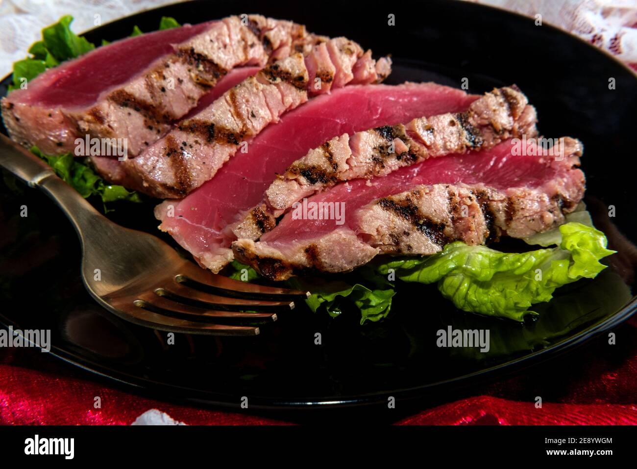Seared ahi tuna with grill marks sliced to reveal tender pink raw ...