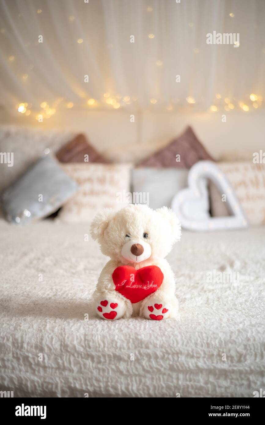 Teddy bear hug heart pillow on bed, Valentine's concept Stock Photo - Alamy