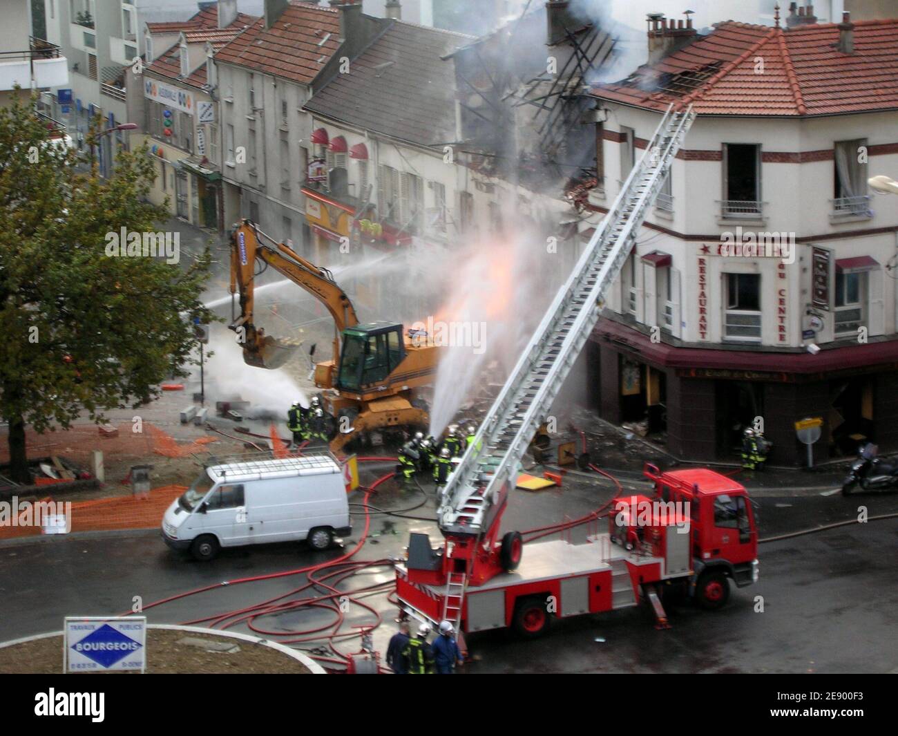 Firefighters work in a street as flames and smoke erupt after a gas ...